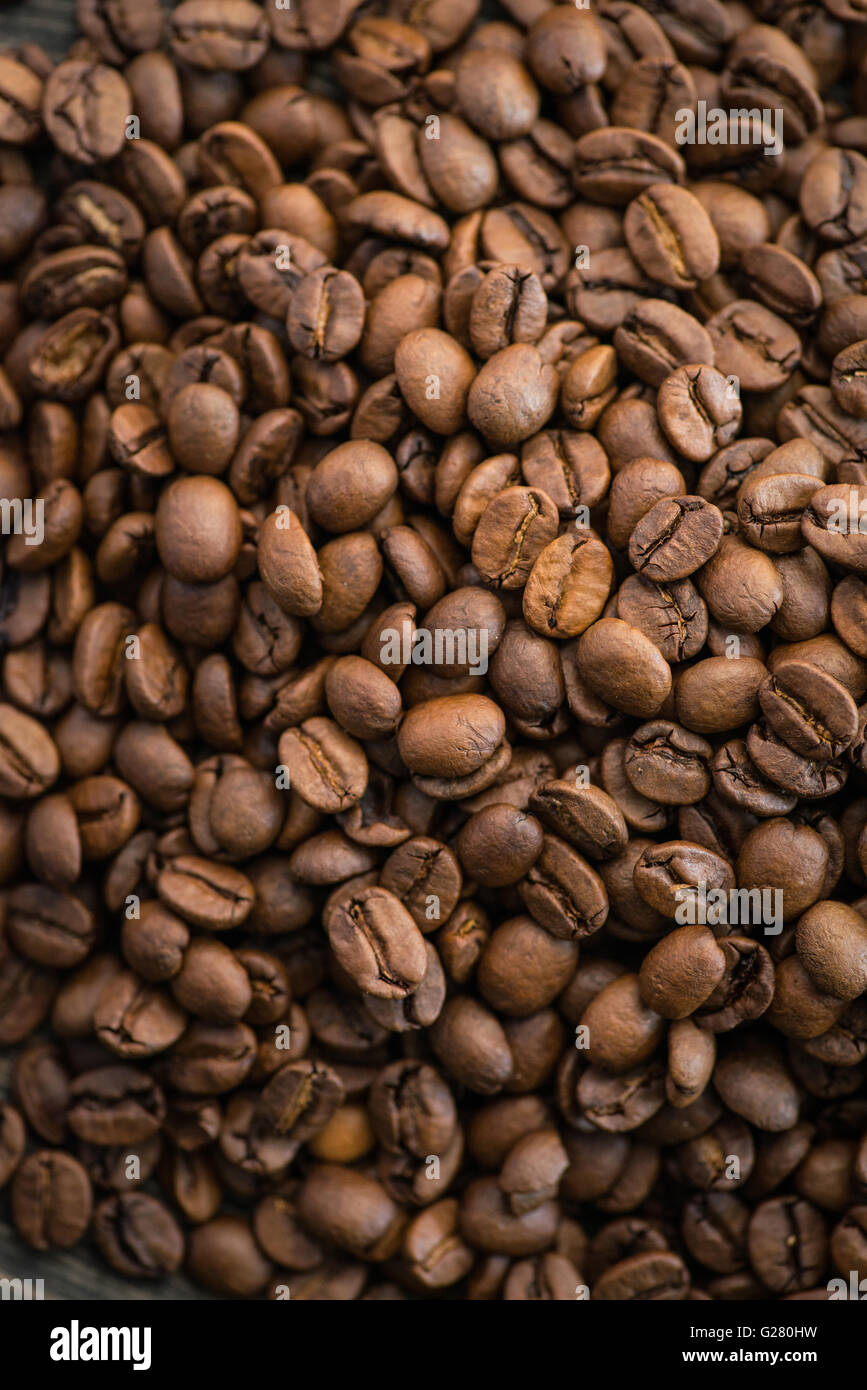 Roasted coffee beans on a rustic wooden table Stock Photo - Alamy