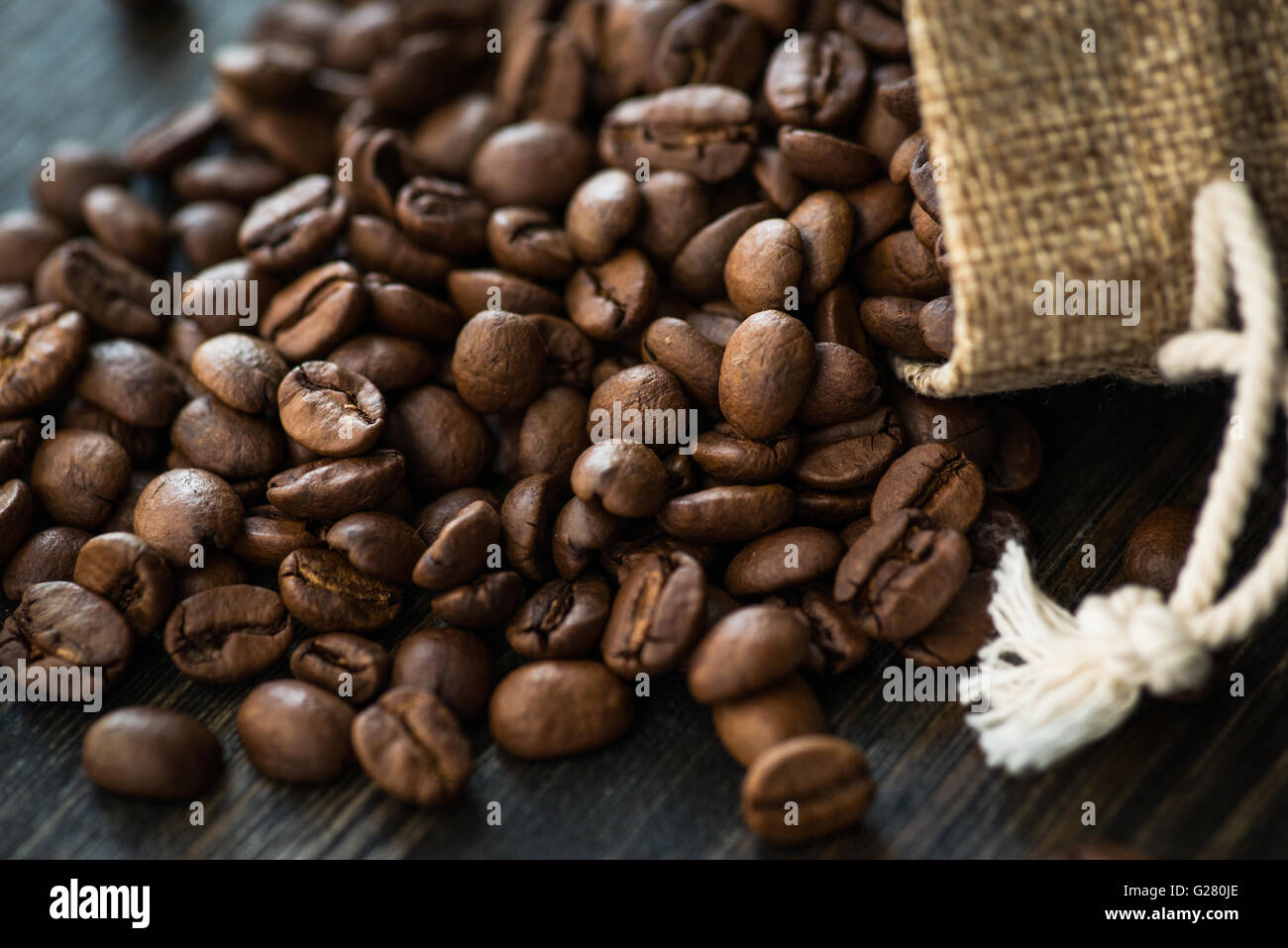 Roasted coffee beans on a rustic wooden table Stock Photo - Alamy