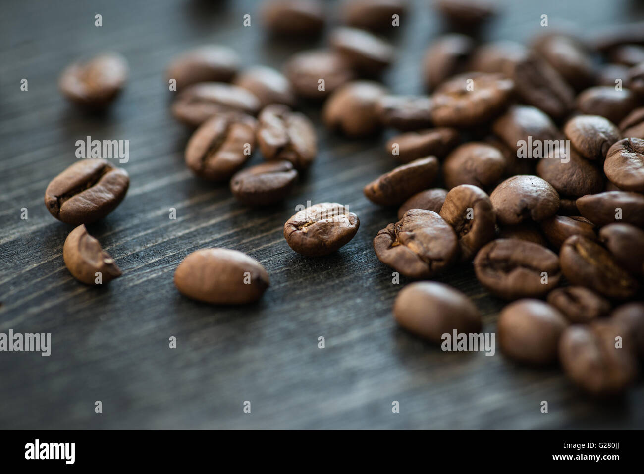 Roasted coffee beans on a rustic wooden table Stock Photo - Alamy