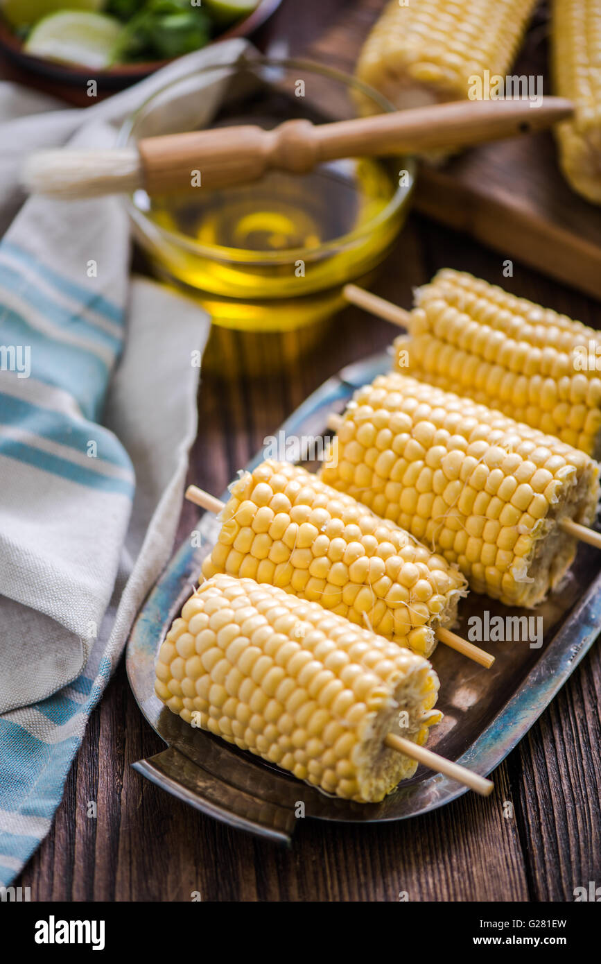 high angle shot of sweetcorn cob ready for bbq, on wooden table Stock ...