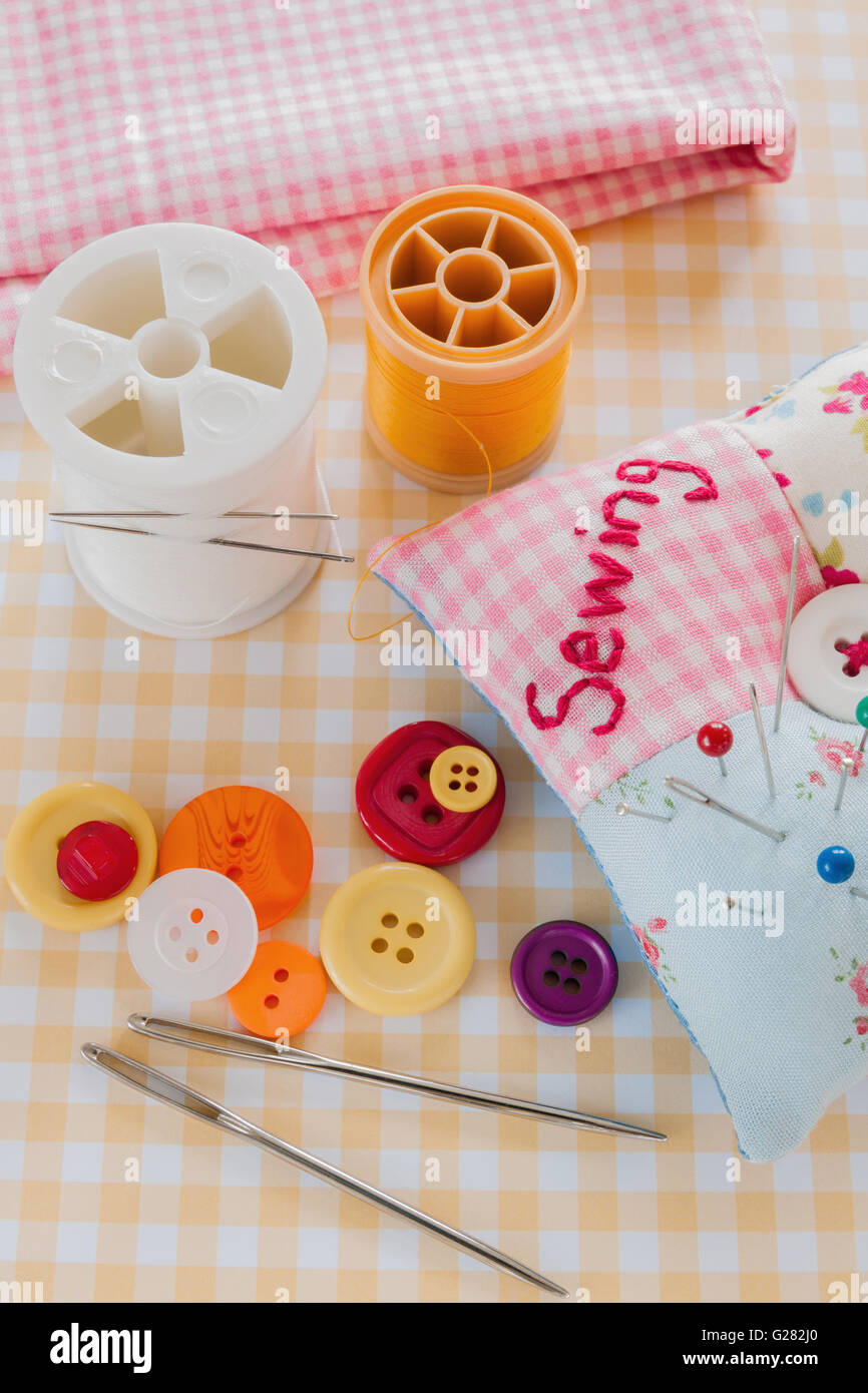 Sewing needles threads and buttons with a pin cushion Stock Photo - Alamy