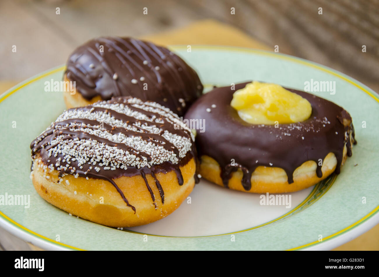 Sweet donuts on a plate on a wood background Stock Photo - Alamy