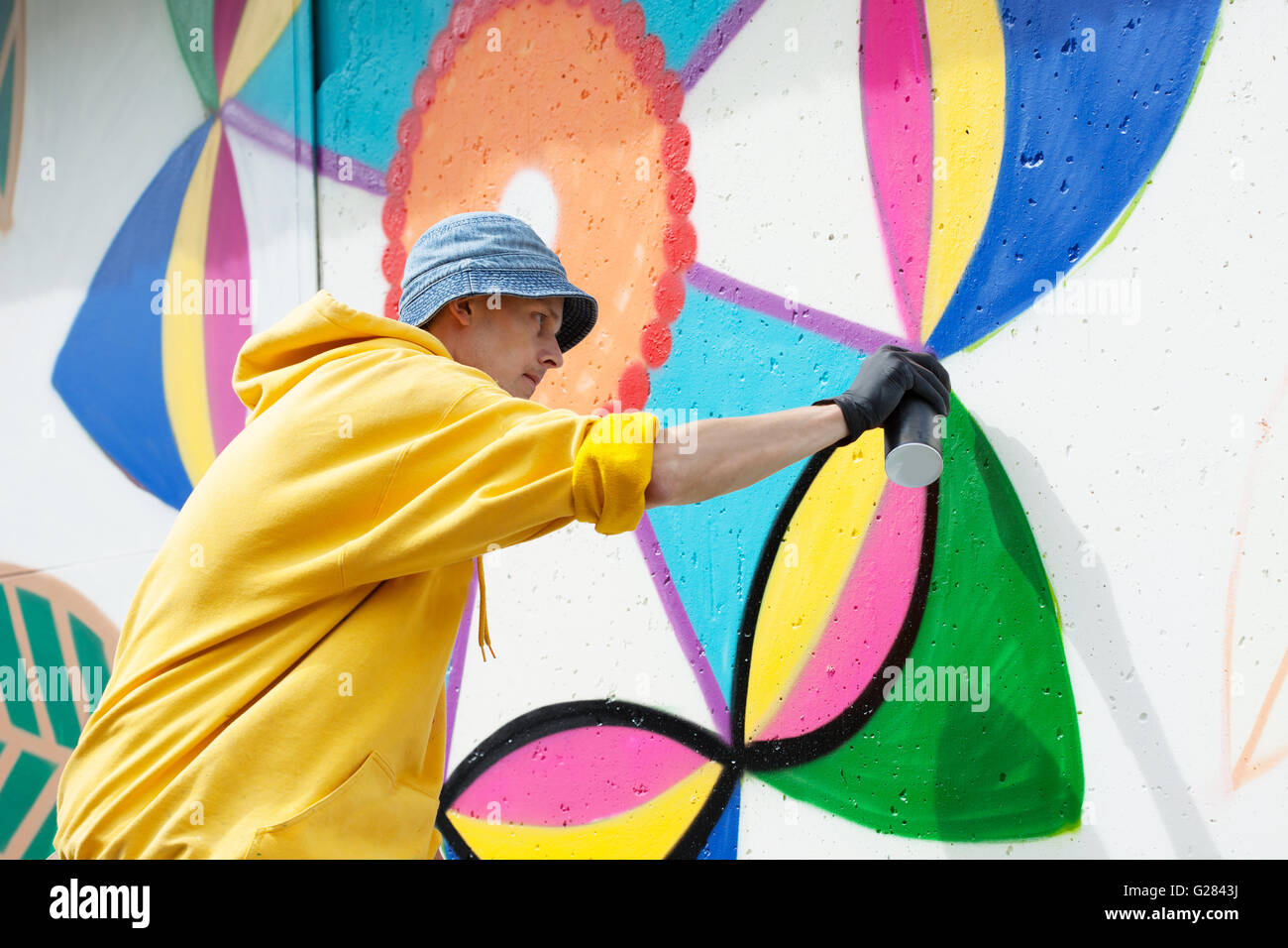 Focused young man painting graffiti on wall Stock Photo - Alamy