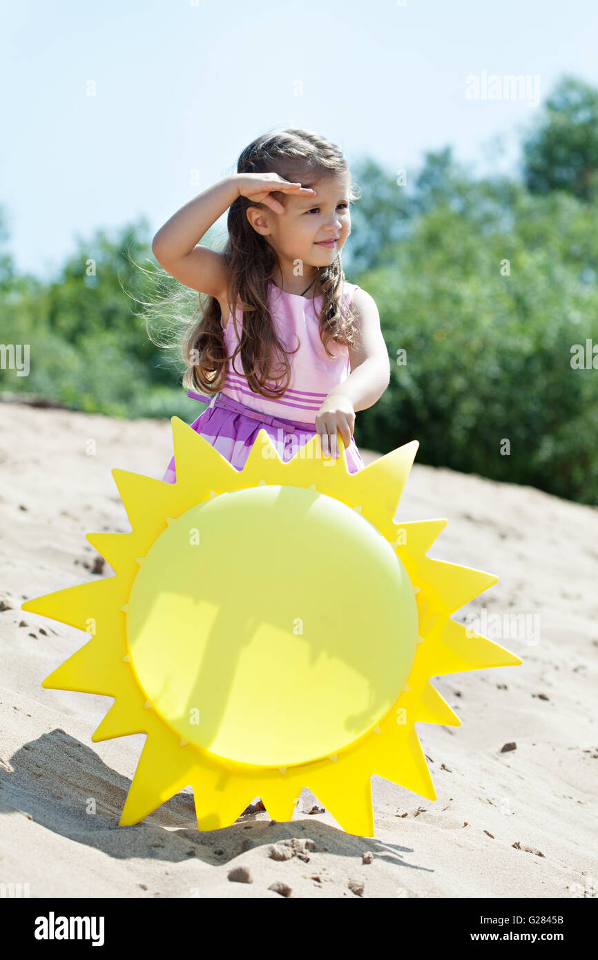 Curious young girl posing with paper sun Stock Photo - Alamy