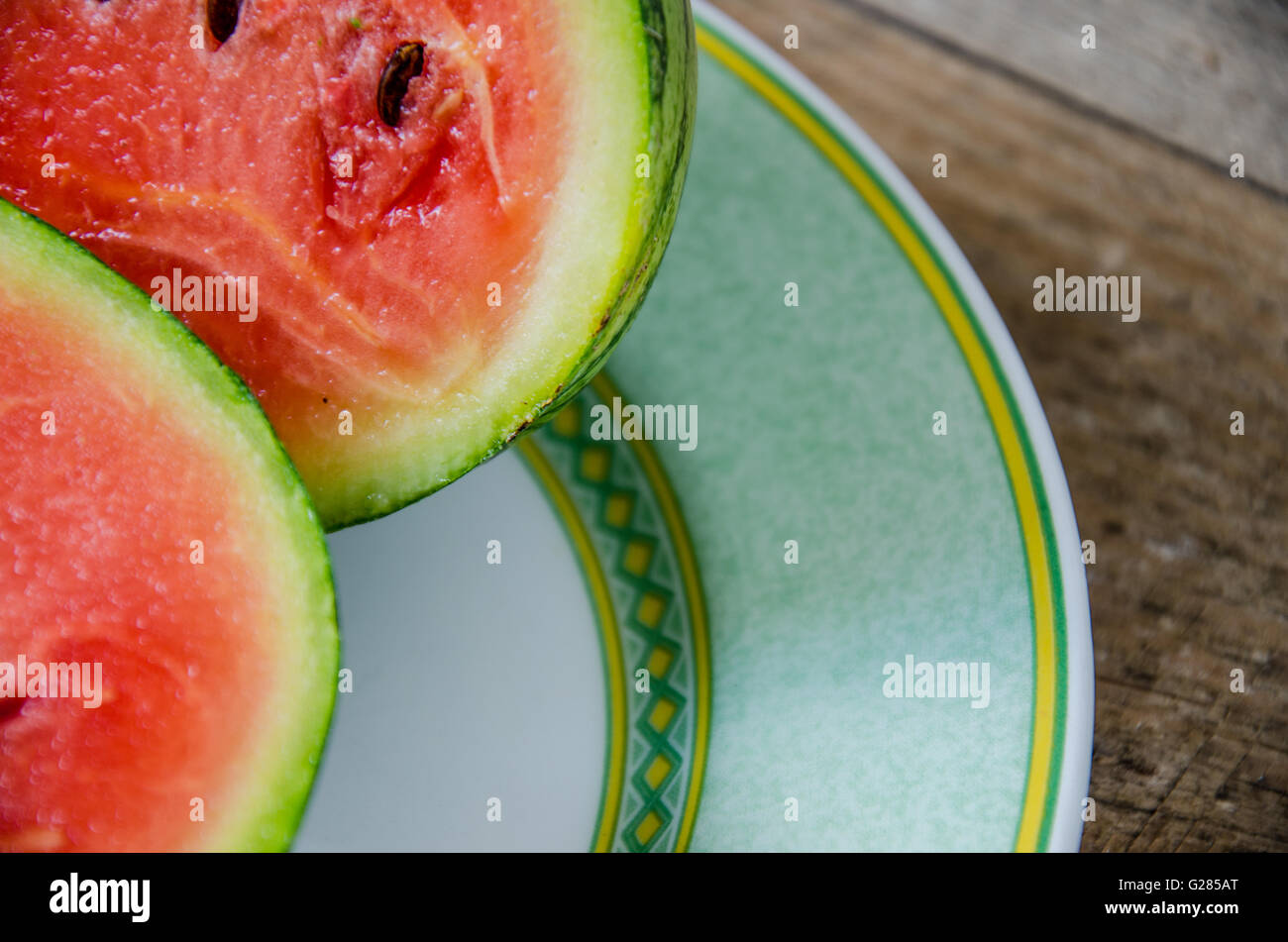 Freshly slices of pink watermelon on a plate on a palet wood surface ...