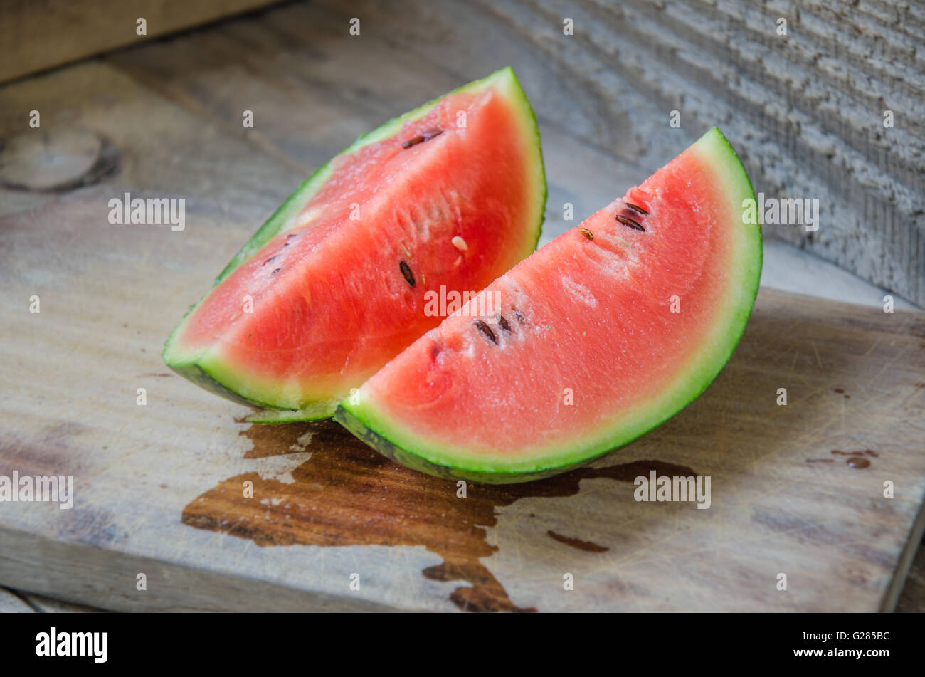 Freshly slices of pink watermelon on a plate on a palet wood surface ...