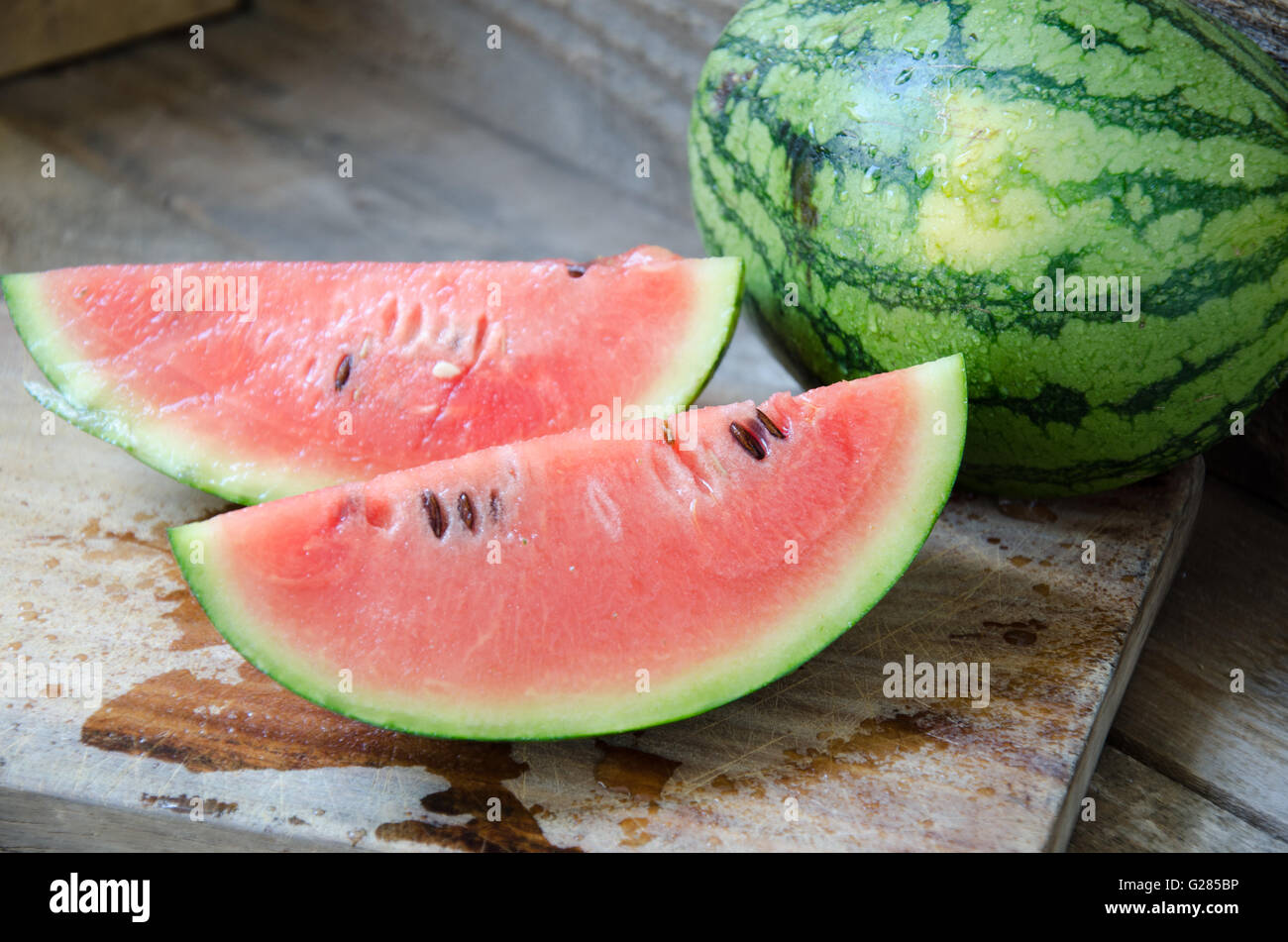 Freshly slices of pink watermelon on a plate on a palet wood surface ...