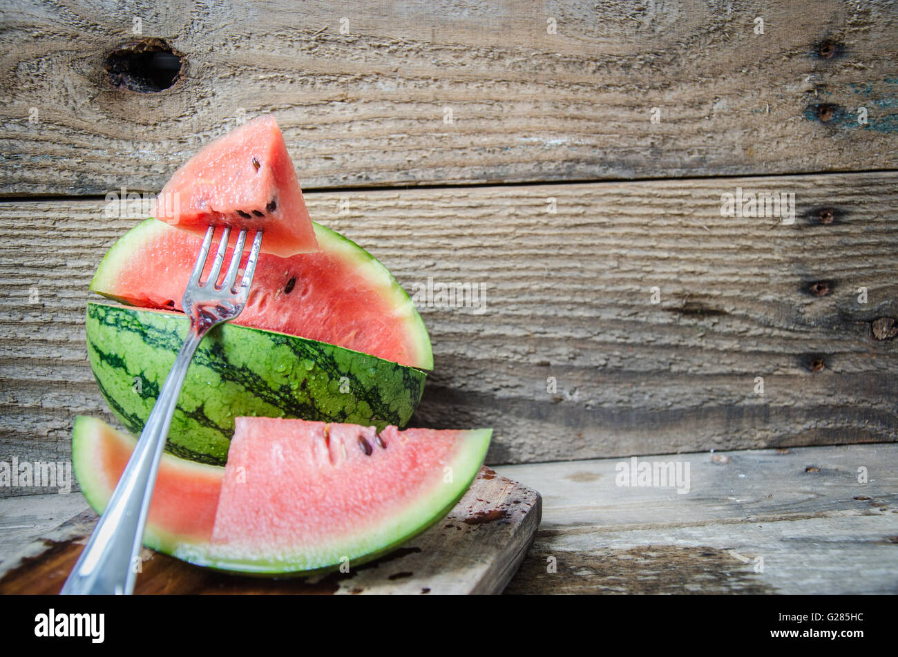 Freshly slices of pink watermelon on a plate on a palet wood surface ...
