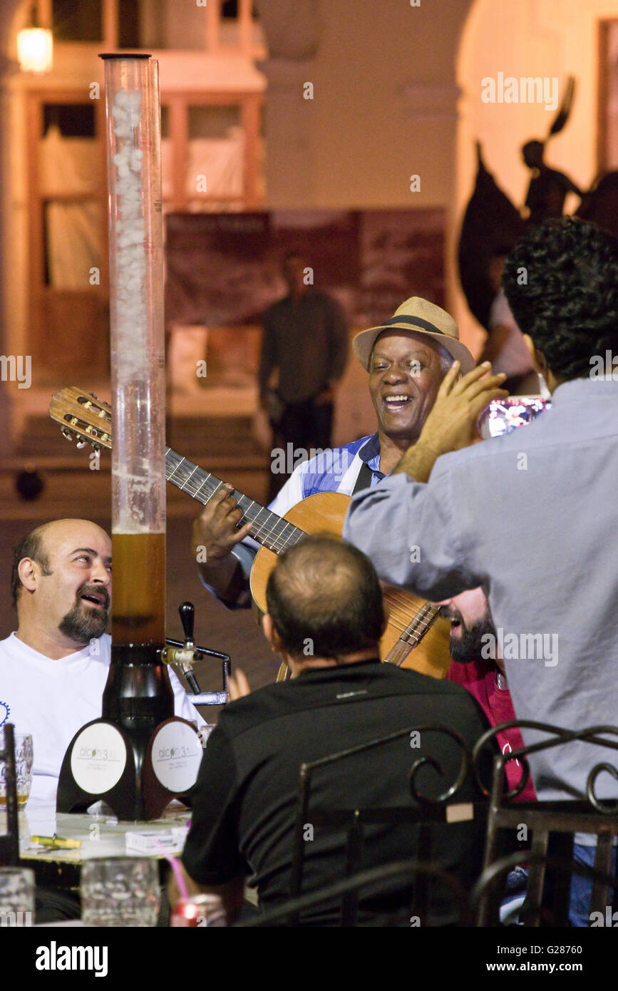 A traditional Cuban musician guitarist entertains people drinking at an ...