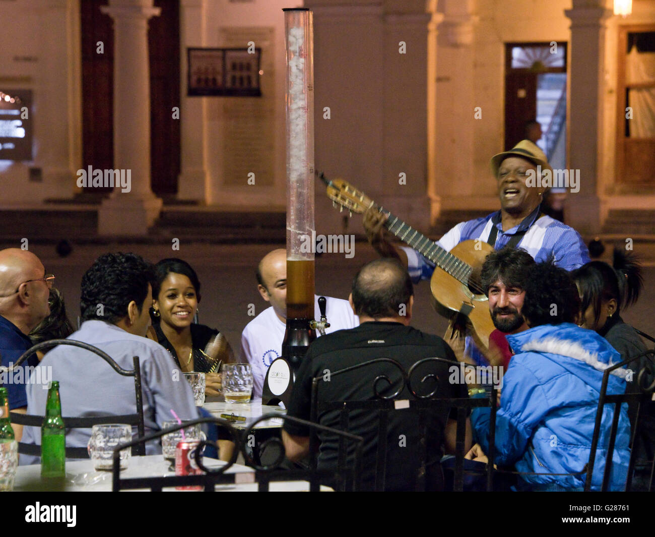 A traditional Cuban musician guitarist entertains people drinking at an ...