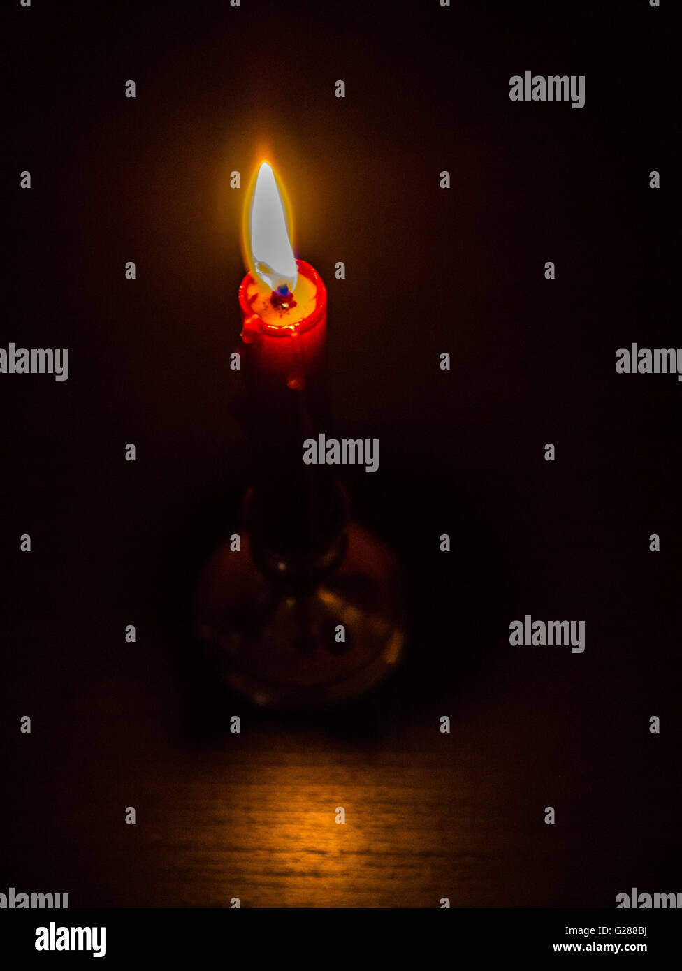 Single, lit, red taper; dark background Stock Photo - Alamy