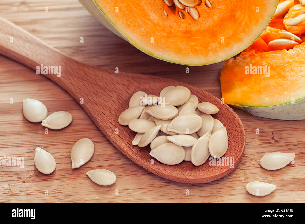 Pumpkin seeds inside of wooden spoon near the pumpkin. Close up. Diet ...