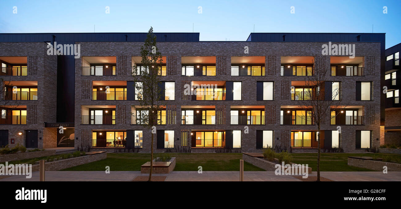 Panoramic front elevation at dusk with lit interiors. Alpine Place ...