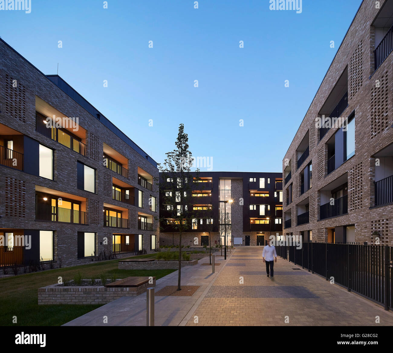 Housing complex with landscaped public spaces at dusk. Alpine Place ...