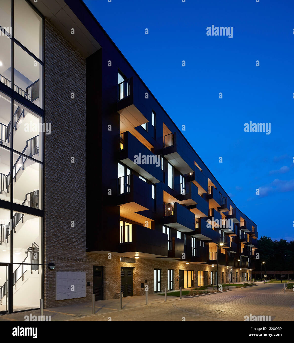 Night perspective along facade with illuminated stairwell. Alpine Place ...