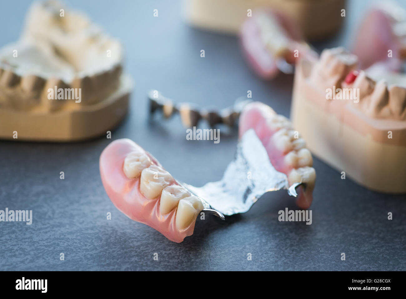 Artificial replacement teeth on a dark surface Stock Photo - Alamy
