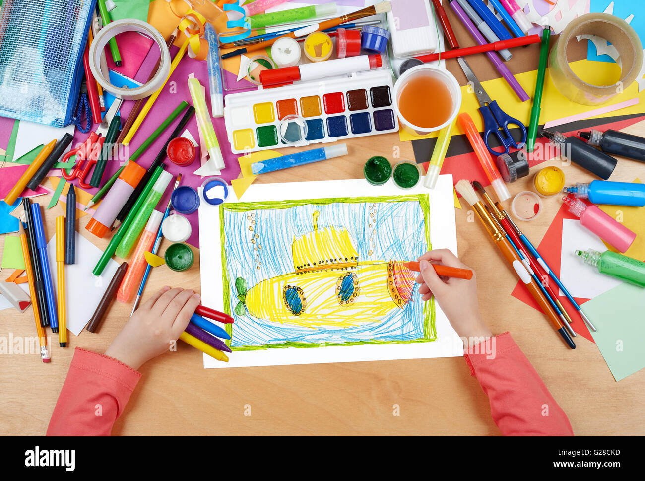 yellow submarine underwater child drawing, top view hands with pencil ...