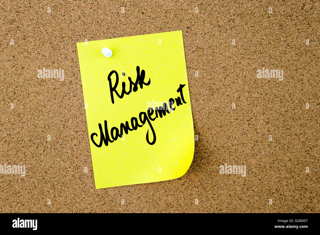 Risk Management written on yellow paper note pinned on cork board with ...