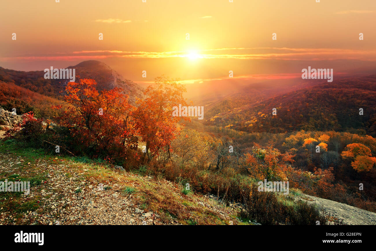 Bright sun over mountains in red autumn Stock Photo - Alamy