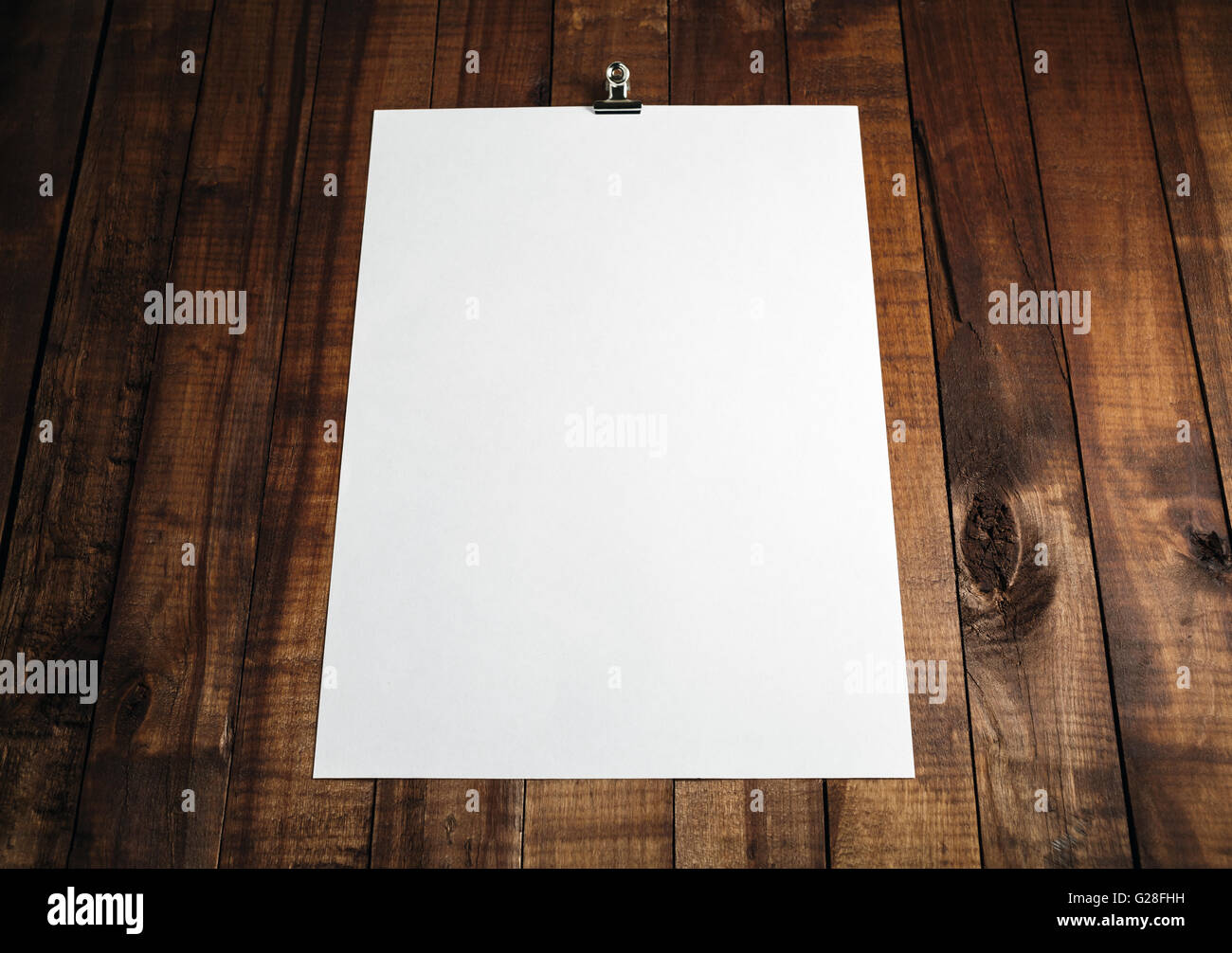 Photo of blank white paper poster on vintage wooden table background ...