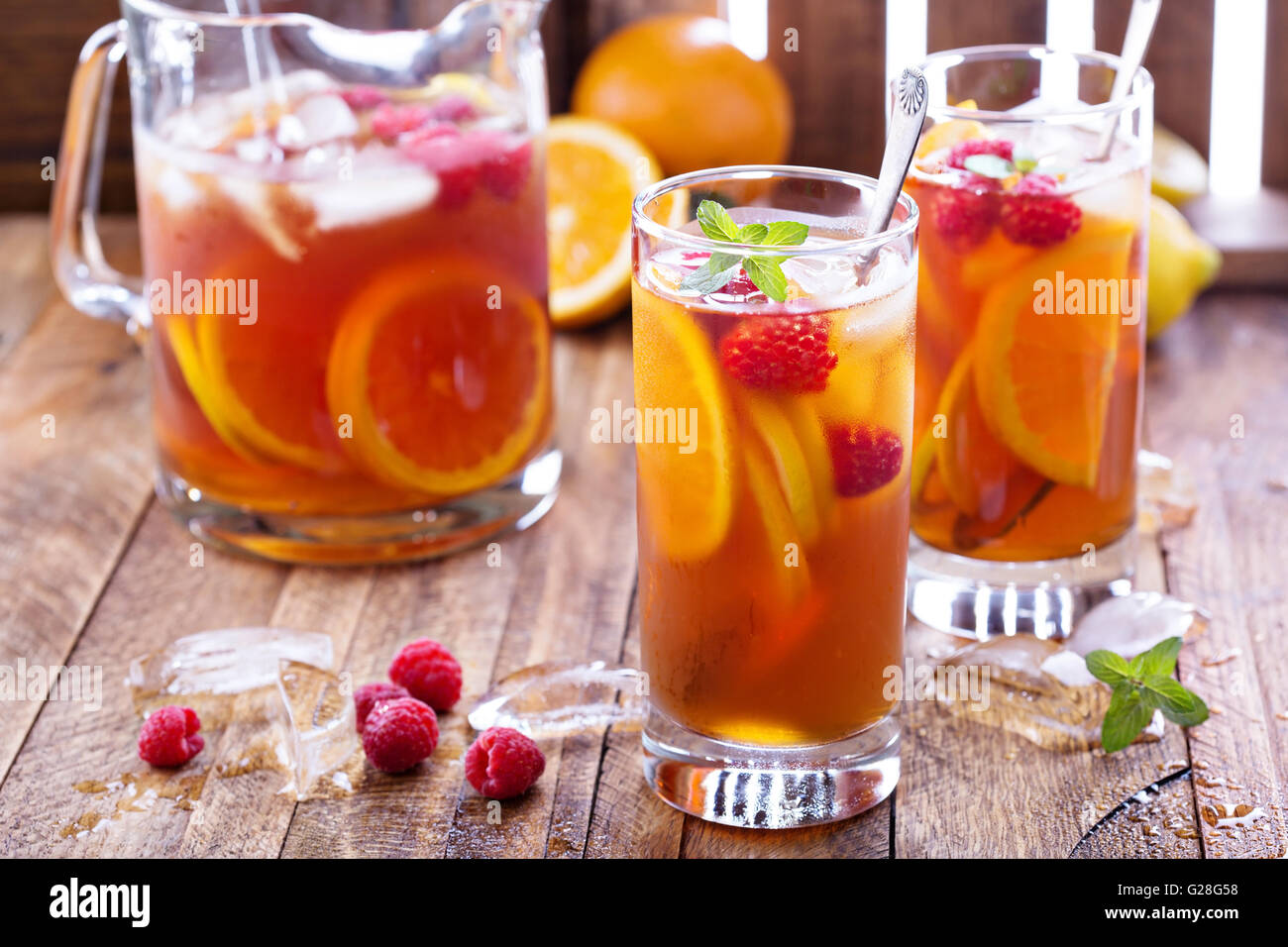 Iced tea with orange and raspberry Stock Photo - Alamy