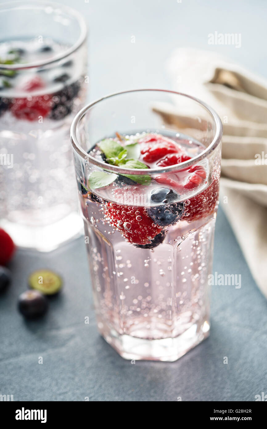 Sparkling water with raspberries and blueberries Stock Photo - Alamy