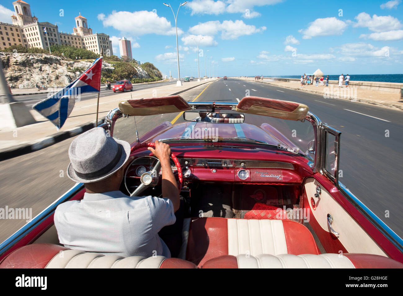 A Cuban taxi driver driving his1955 Pontiac Star Chief convertible ...