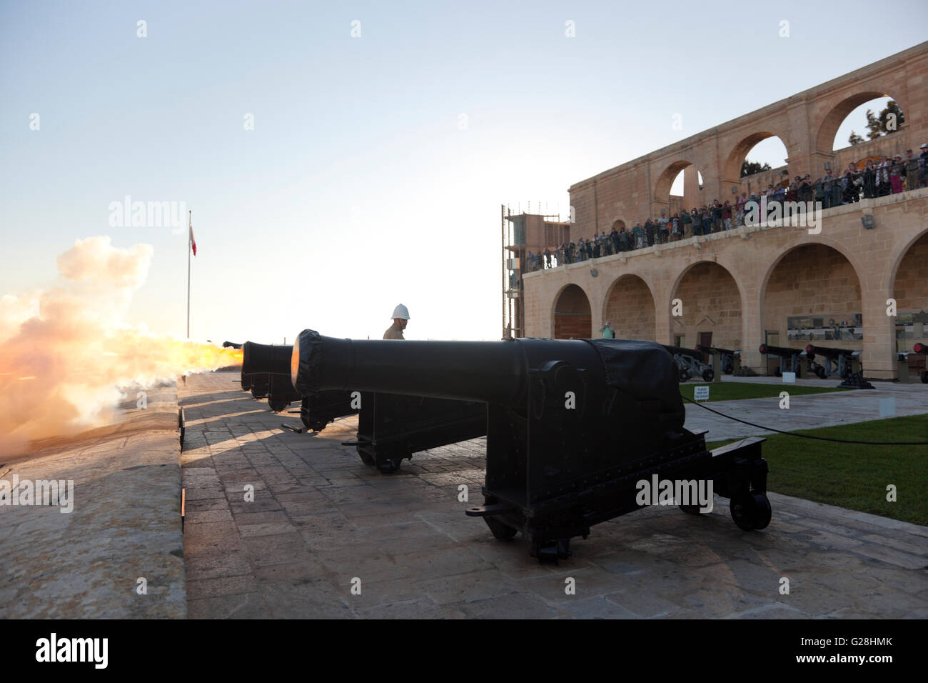 A reenactor in British military fatigues fires a blank shell from ...