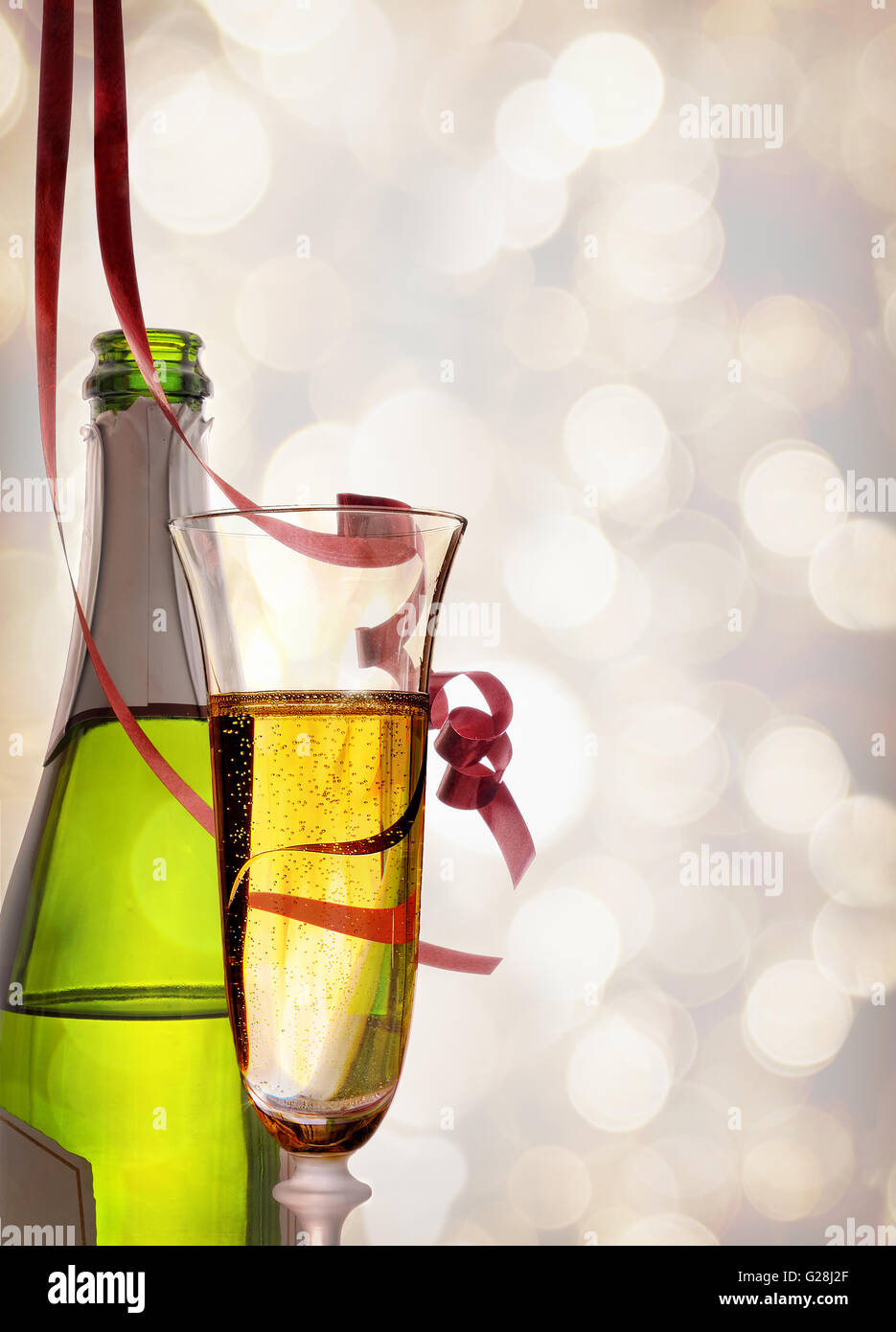 Glass and bottle of sparkling white wine with bokeh background. With ...
