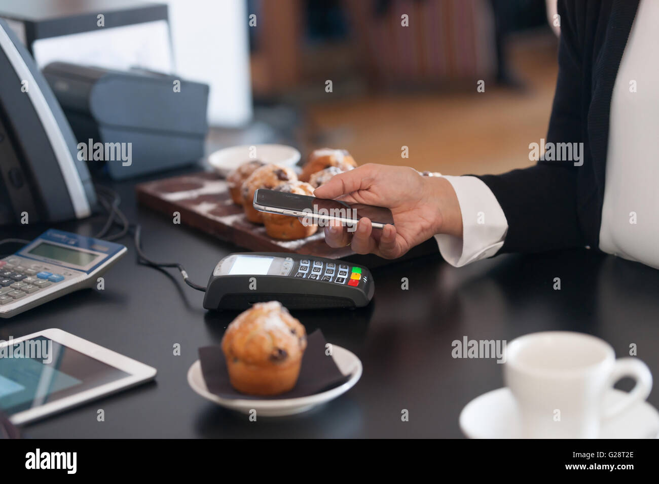 Making contactless payment at cafe counter with mobile phone Stock ...