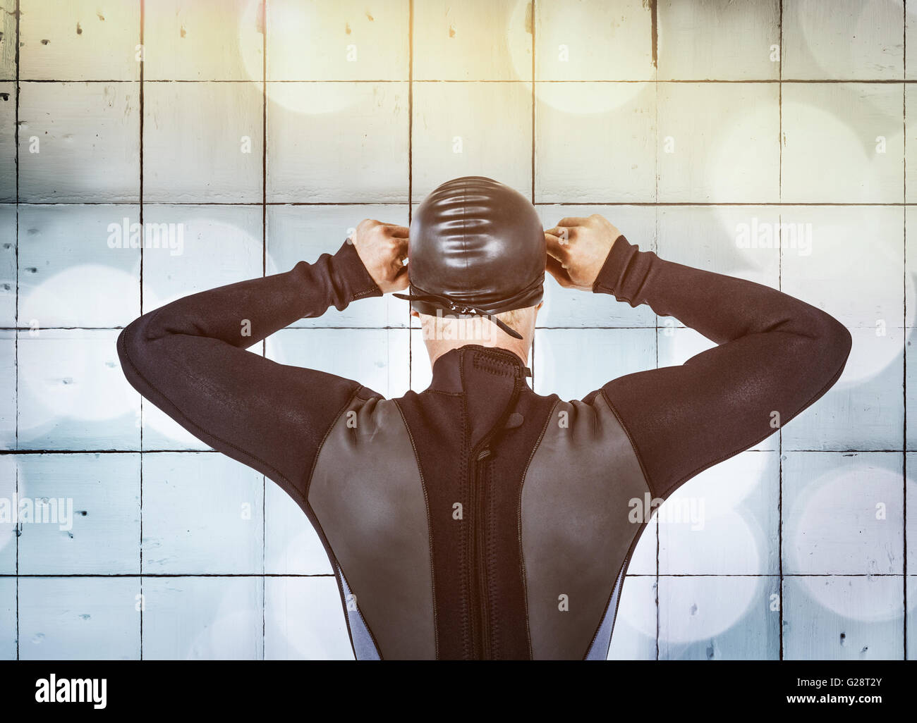 Composite image of rear view of swimmer in wetsuit wearing swimming ...