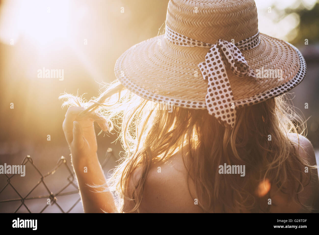 Woman from behind wearing summer hat Stock Photo - Alamy