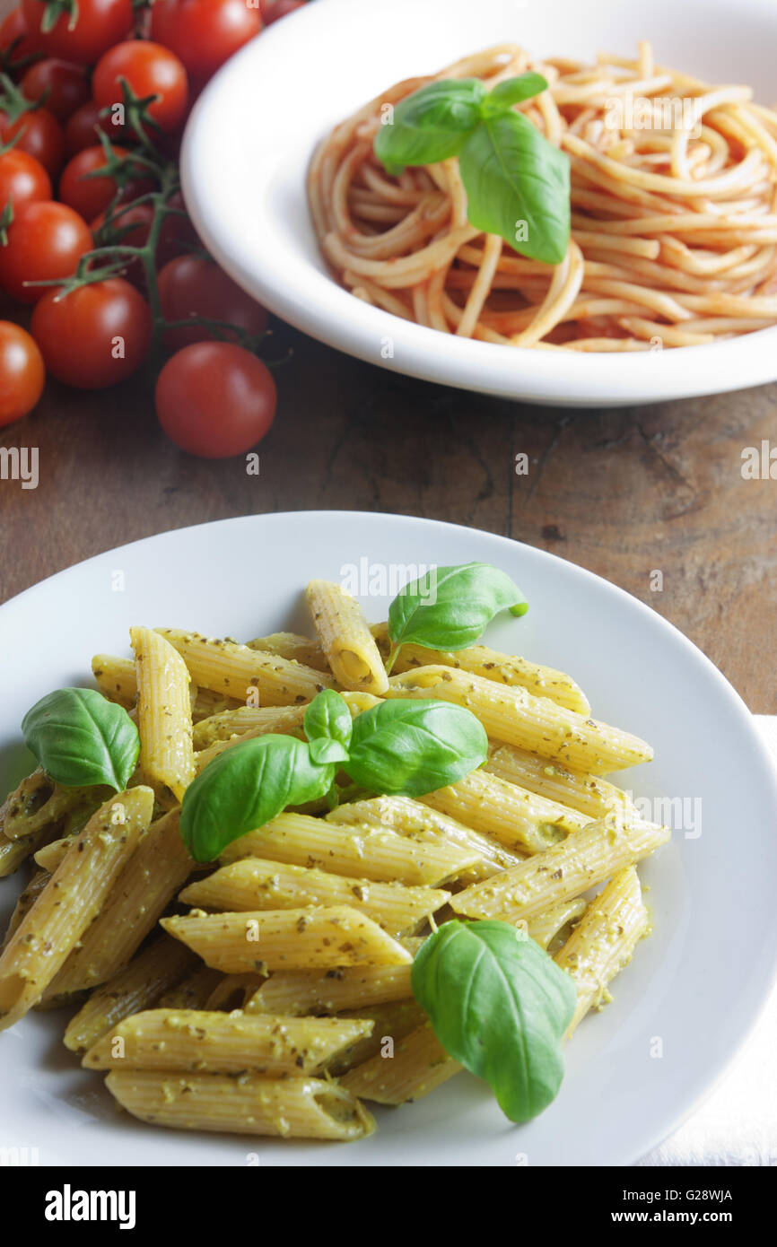 Two plates of pasta with pesto and tomato sauce Stock Photo - Alamy