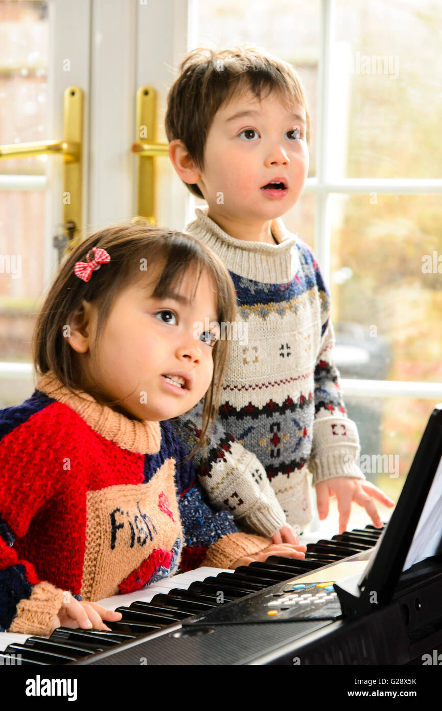 Kids playing piano Stock Photo - Alamy