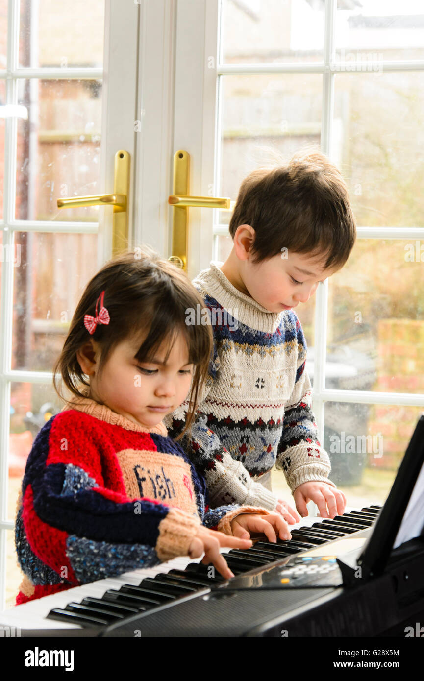 Kids playing piano Stock Photo - Alamy