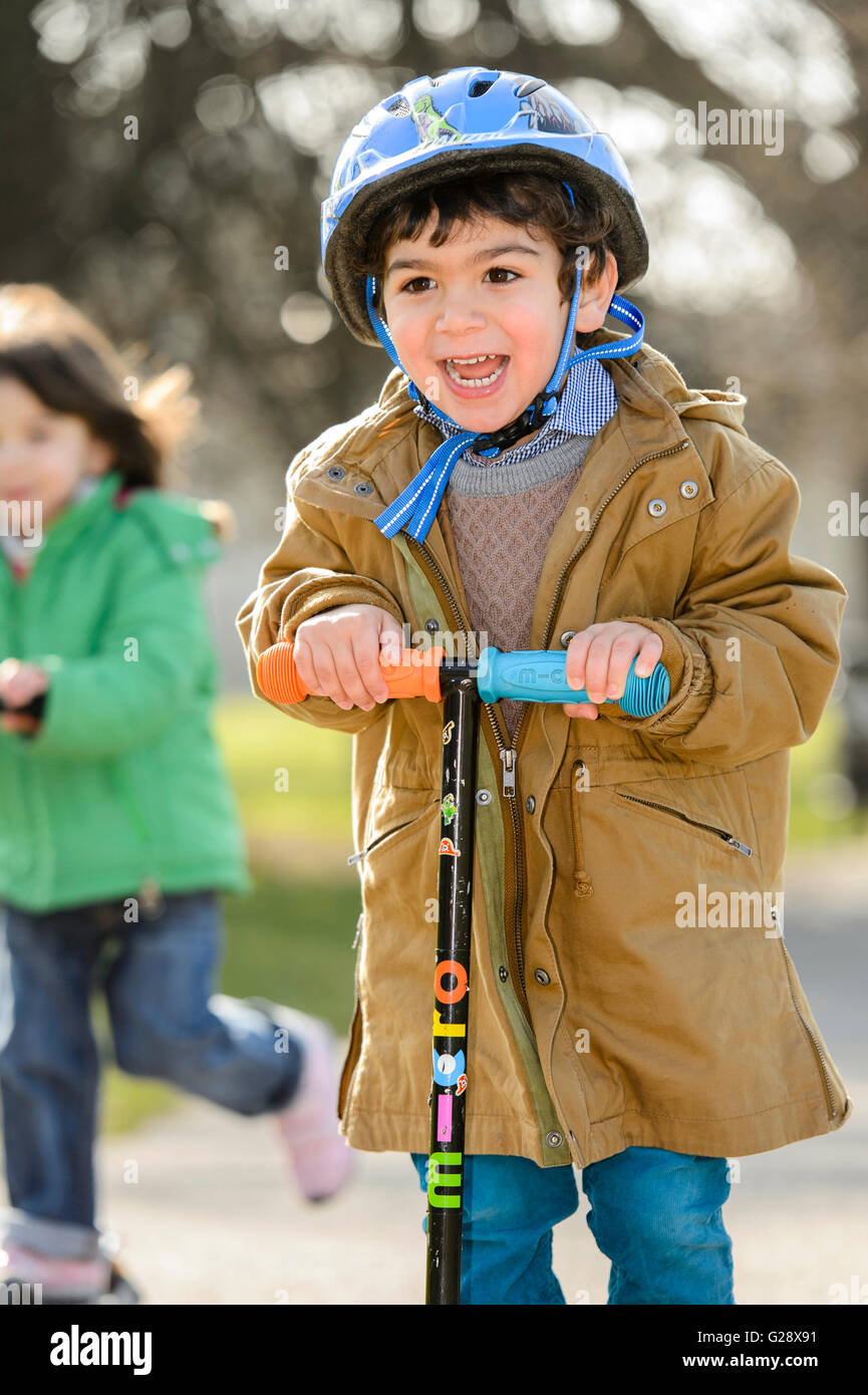 Kids playing with kickboards in a park Stock Photo - Alamy