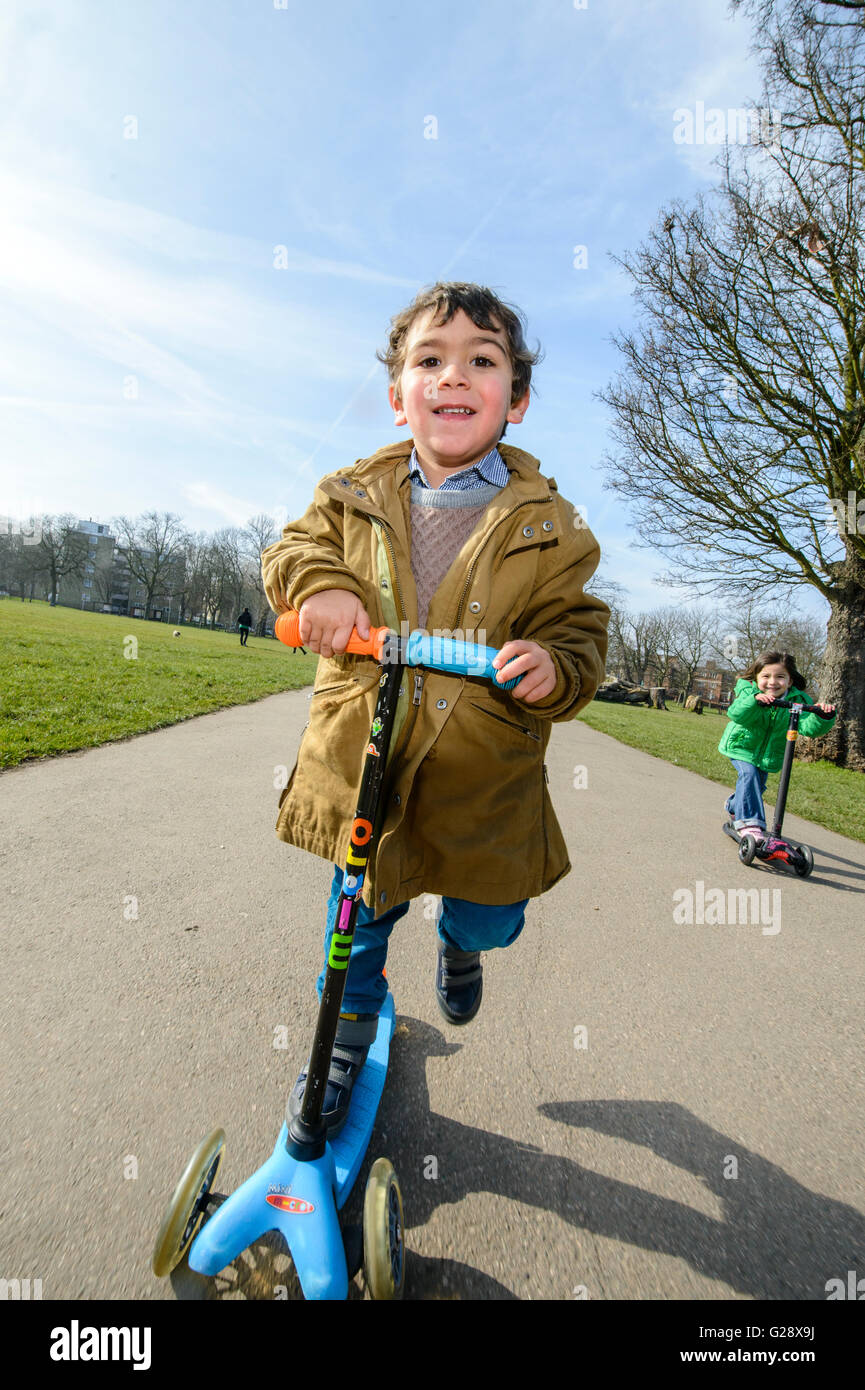 Kids playing with kickboards in a park Stock Photo - Alamy