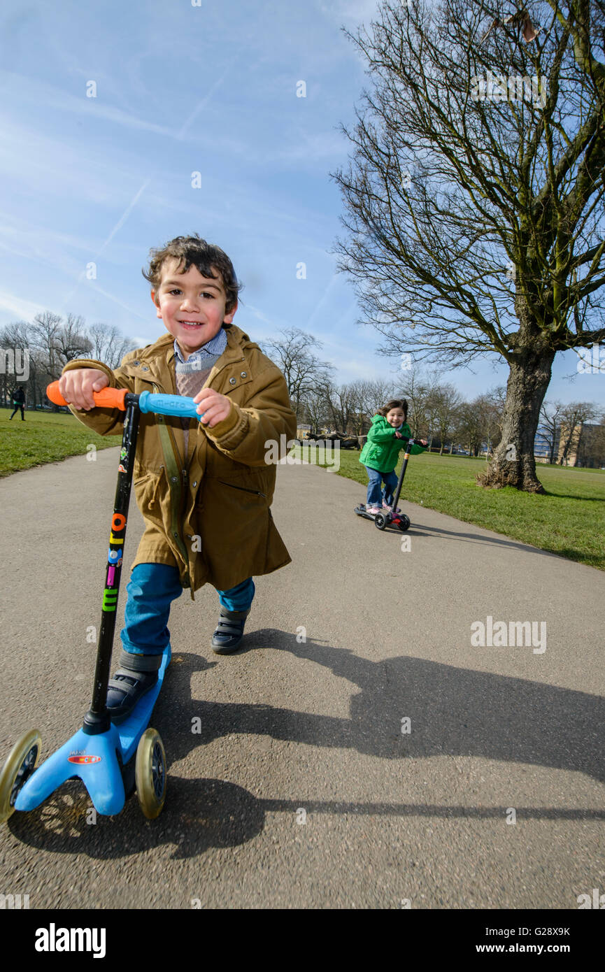 Kids playing with kickboards in a park Stock Photo - Alamy