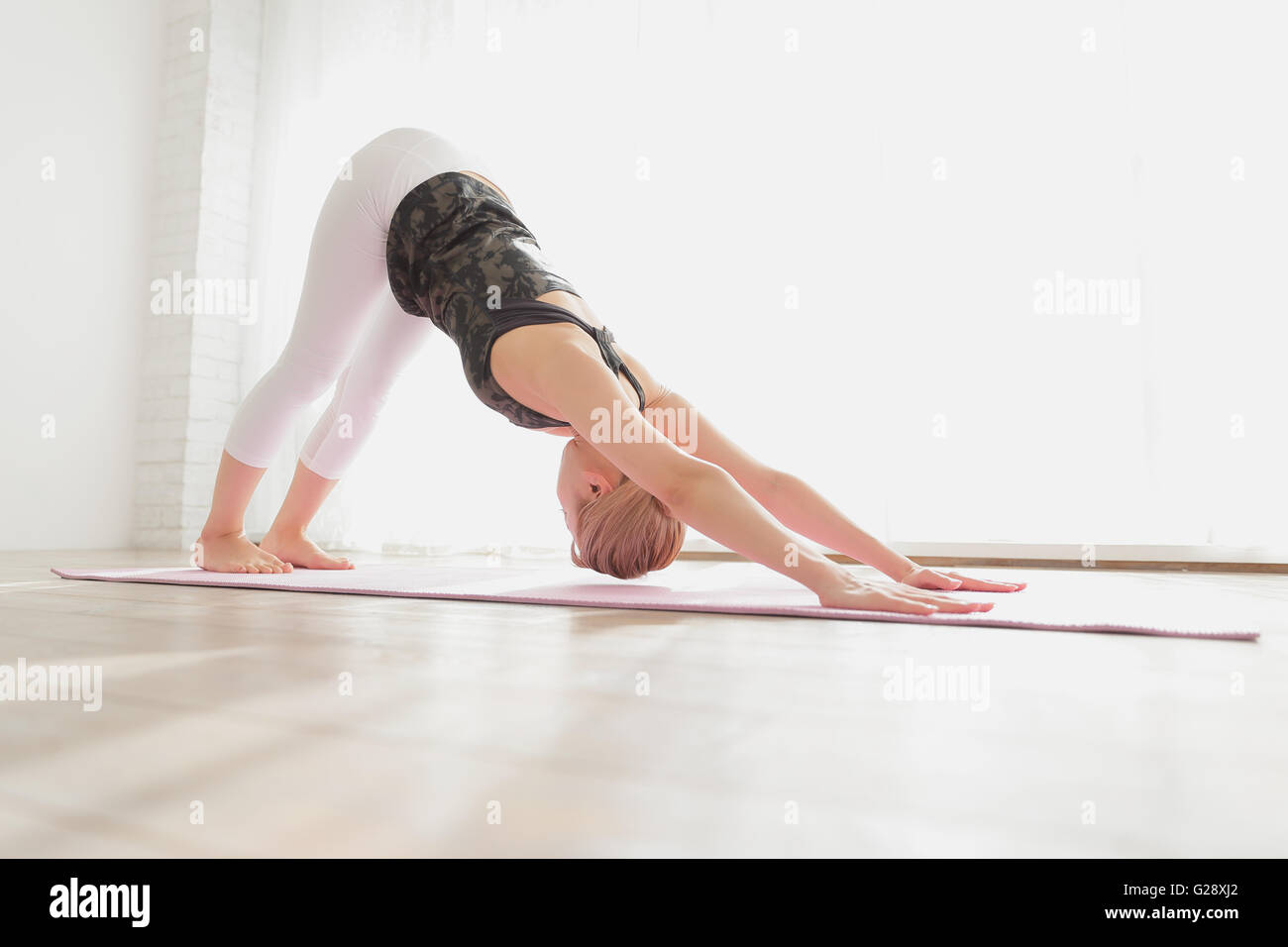 Attractive young Japanese practicing yoga in an airy room Stock Photo ...