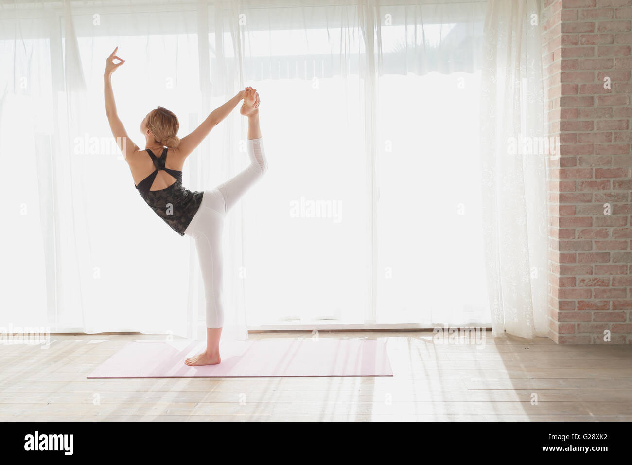 Attractive young Japanese practicing yoga in an airy room Stock Photo ...