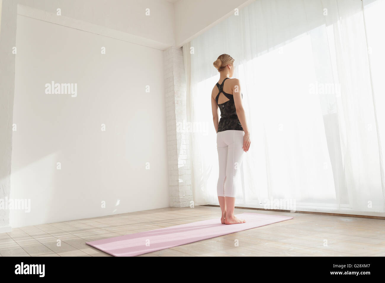 Attractive young Japanese practicing yoga in an airy room Stock Photo ...