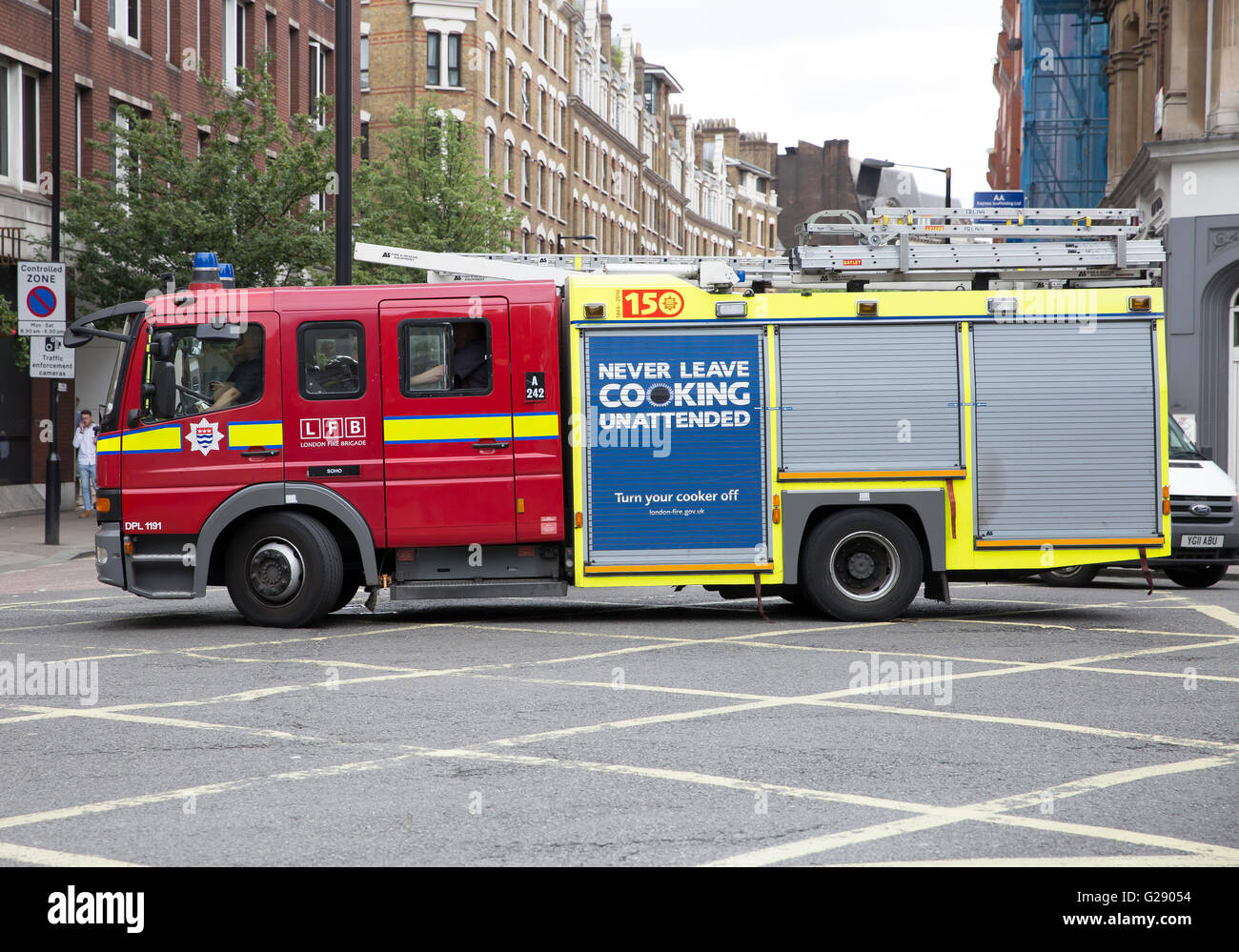 A red fire engine sits in a box road junction in London Stock Photo - Alamy