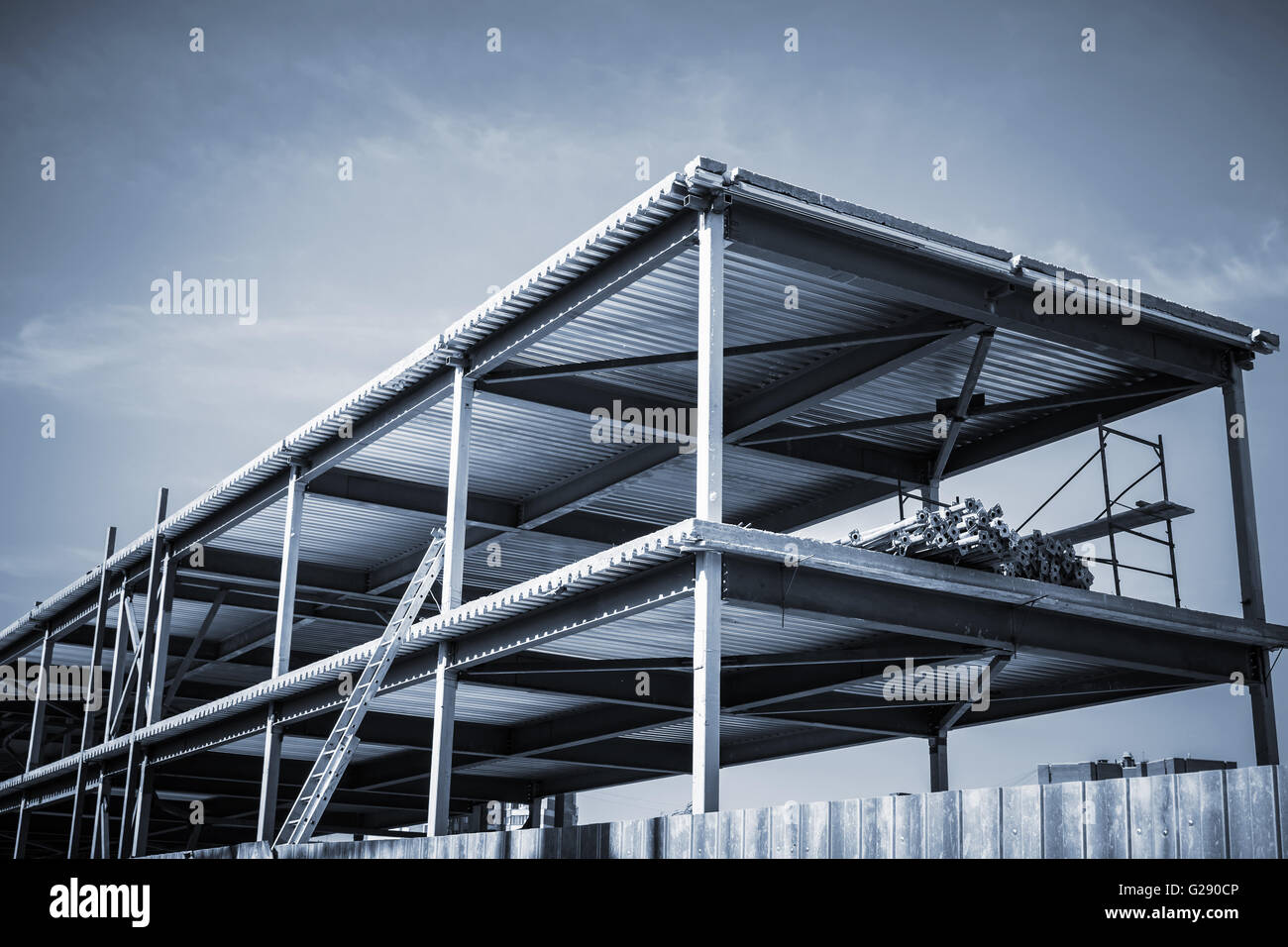 Modern industrial building is under construction. Dark blue toned photo ...
