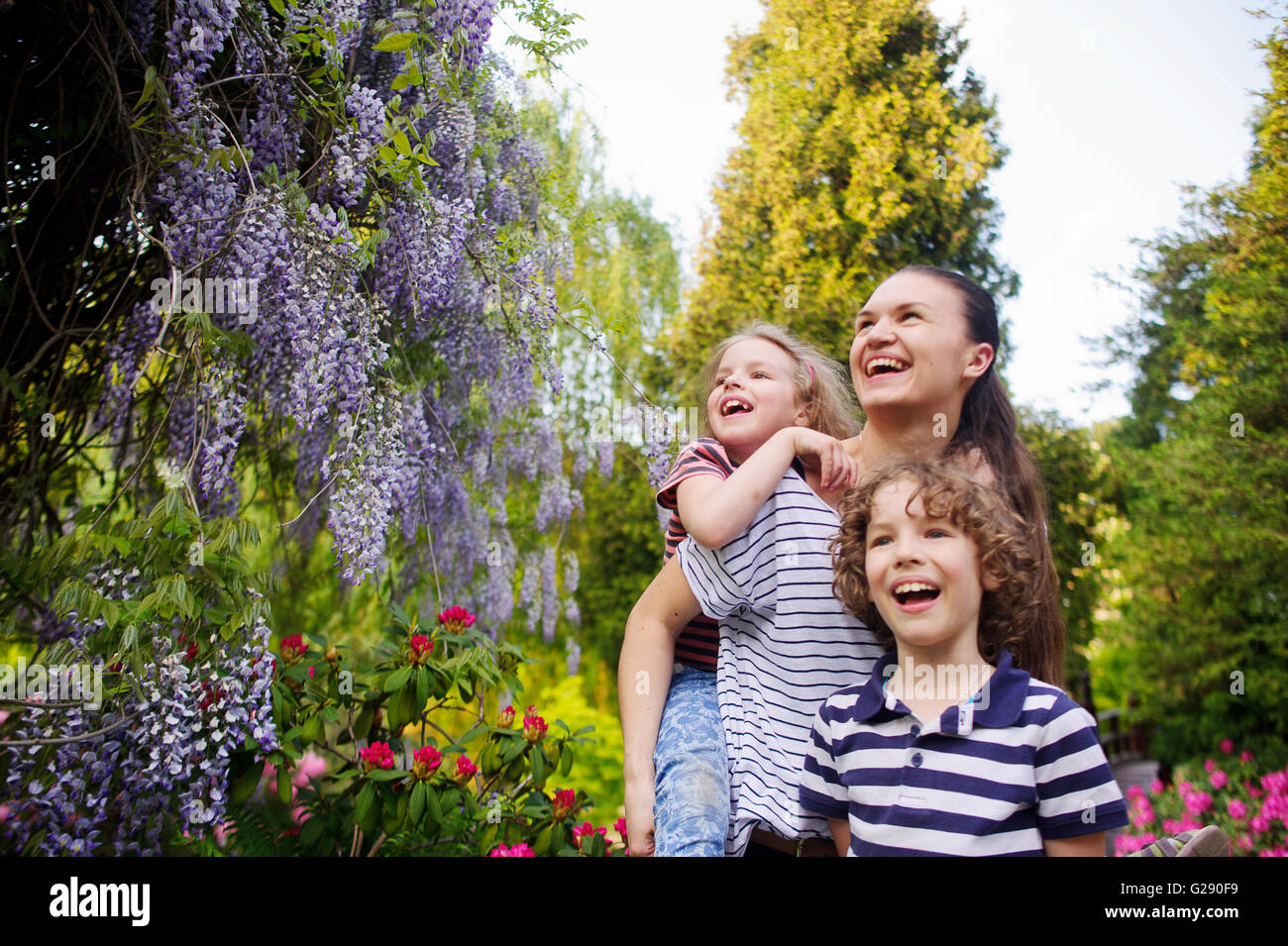 Young woman with two children in the summer park. A warm sunny day ...