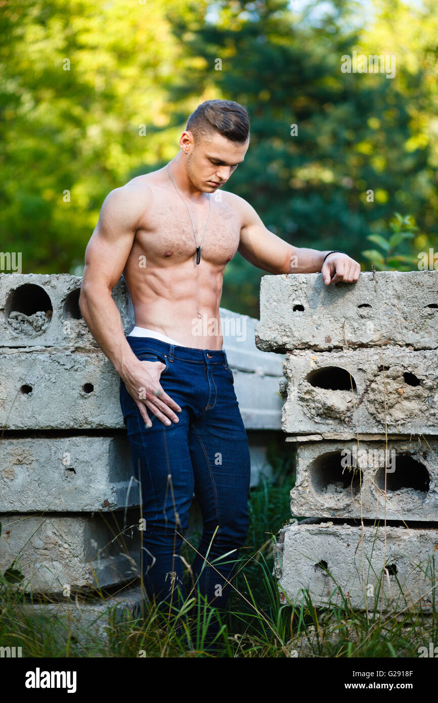 Muscular young man near concrete slab Stock Photo - Alamy
