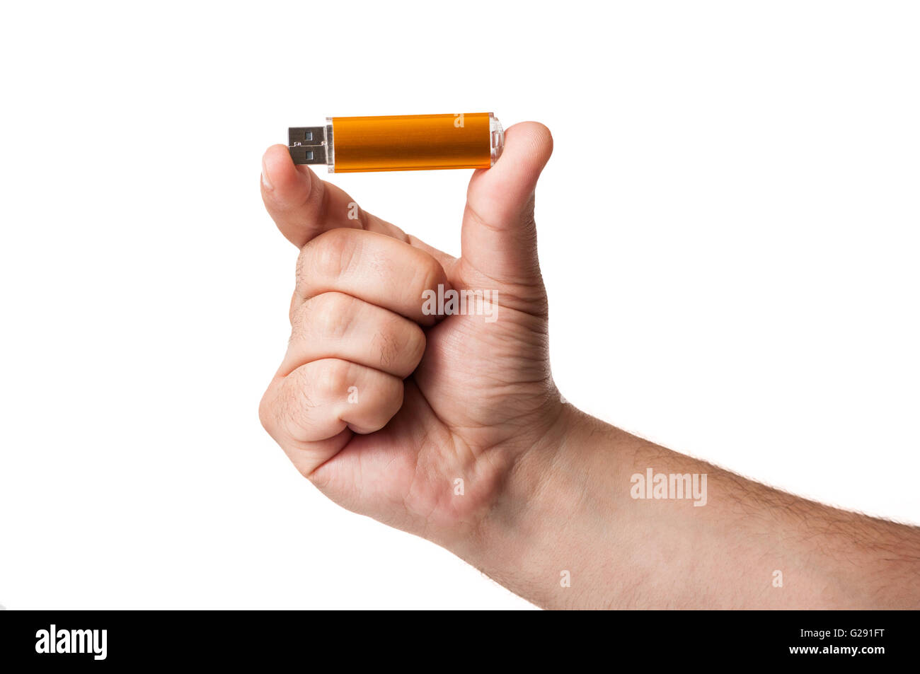 A golden USB memory stick hold between 2 fingers isolated on a white ...