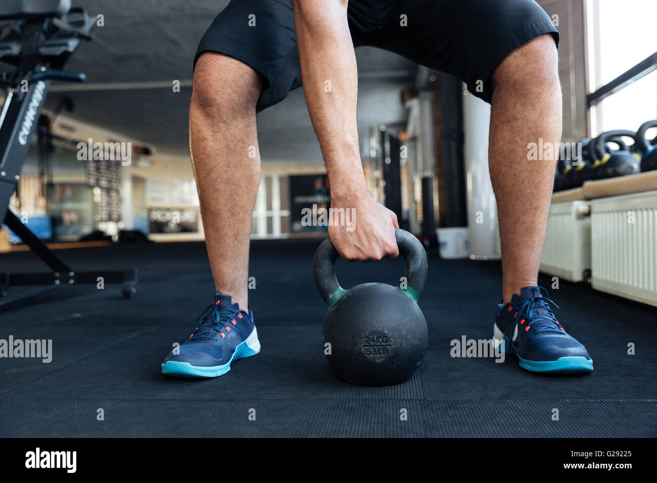 Cropped image of a bodybuilder using kettlebell in his workout at the ...