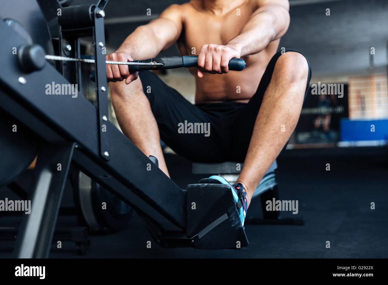 Cropped image of a fitness man using rowing machine in the gym Stock ...