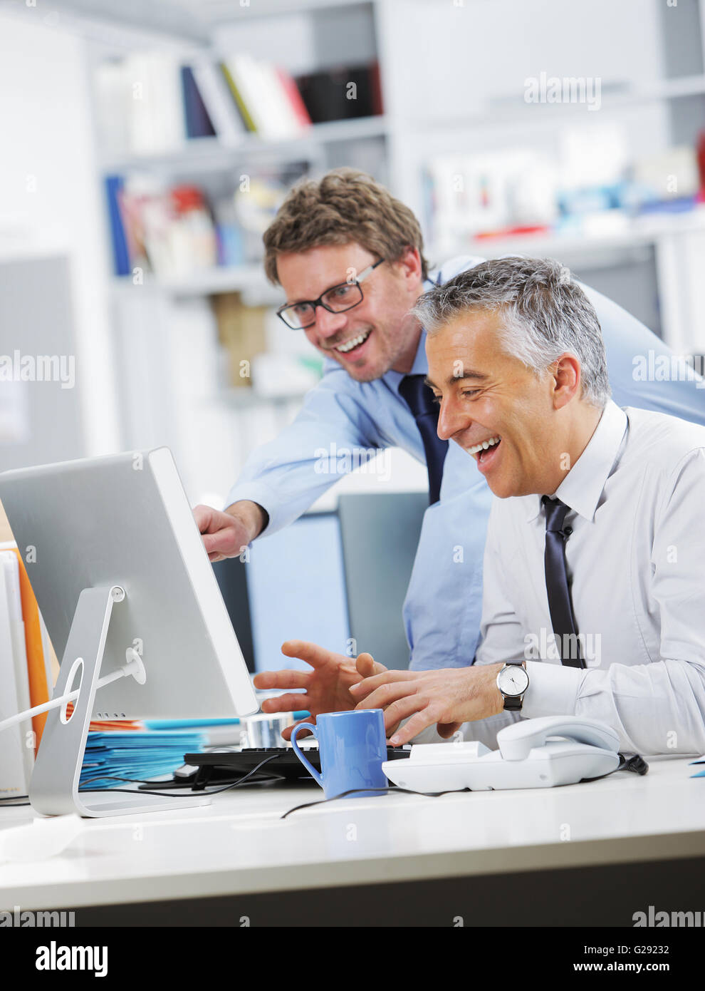Business people laughing in front of a screen computer Stock Photo - Alamy