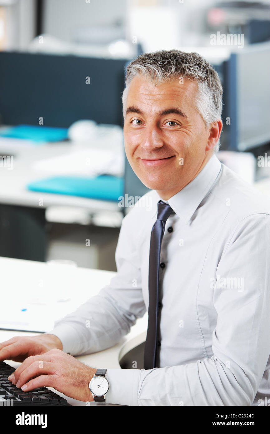 Handsome businessman sitting at his desk Stock Photo - Alamy